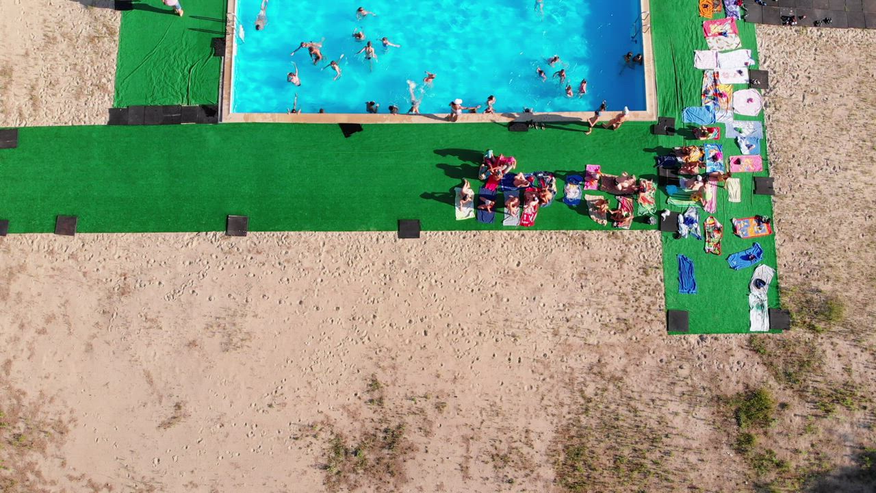 Flying over a crowded swimming pool - Free Stock Video