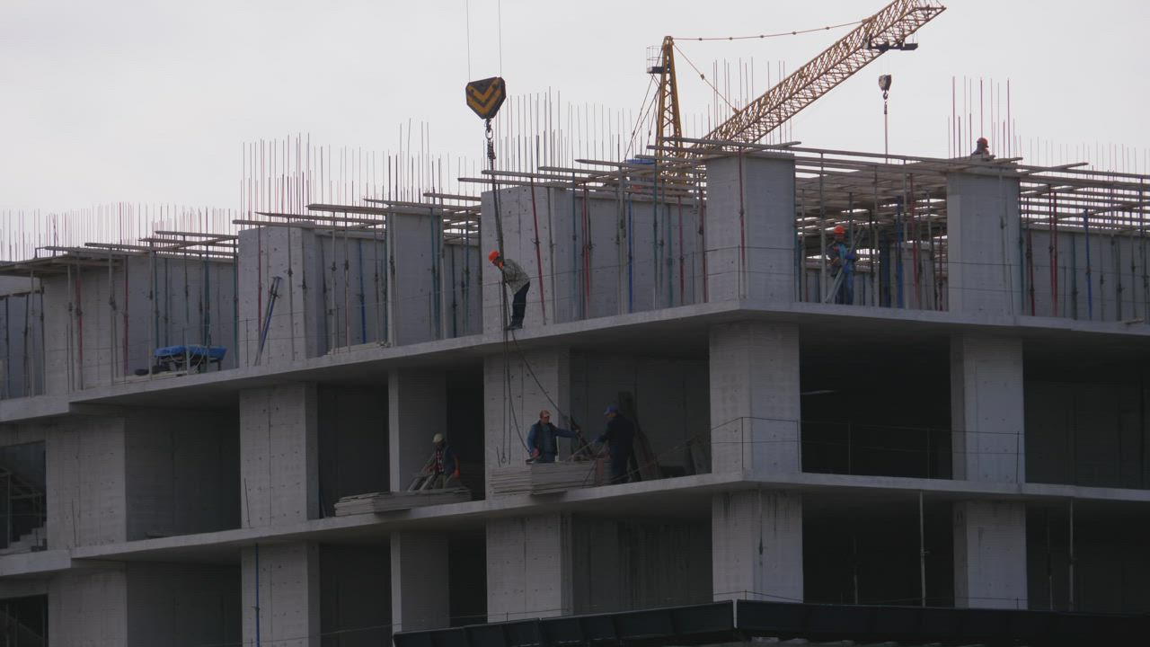Builders lifting a load in the construction site - Free Stock Video