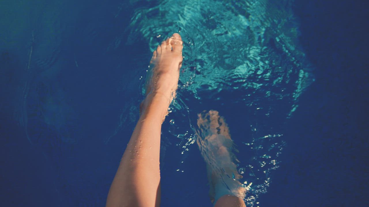 Person splashing feet in a pool - Free Stock Video