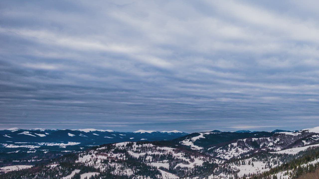 Cloudy sky over winter forested mountains - Free Stock Video