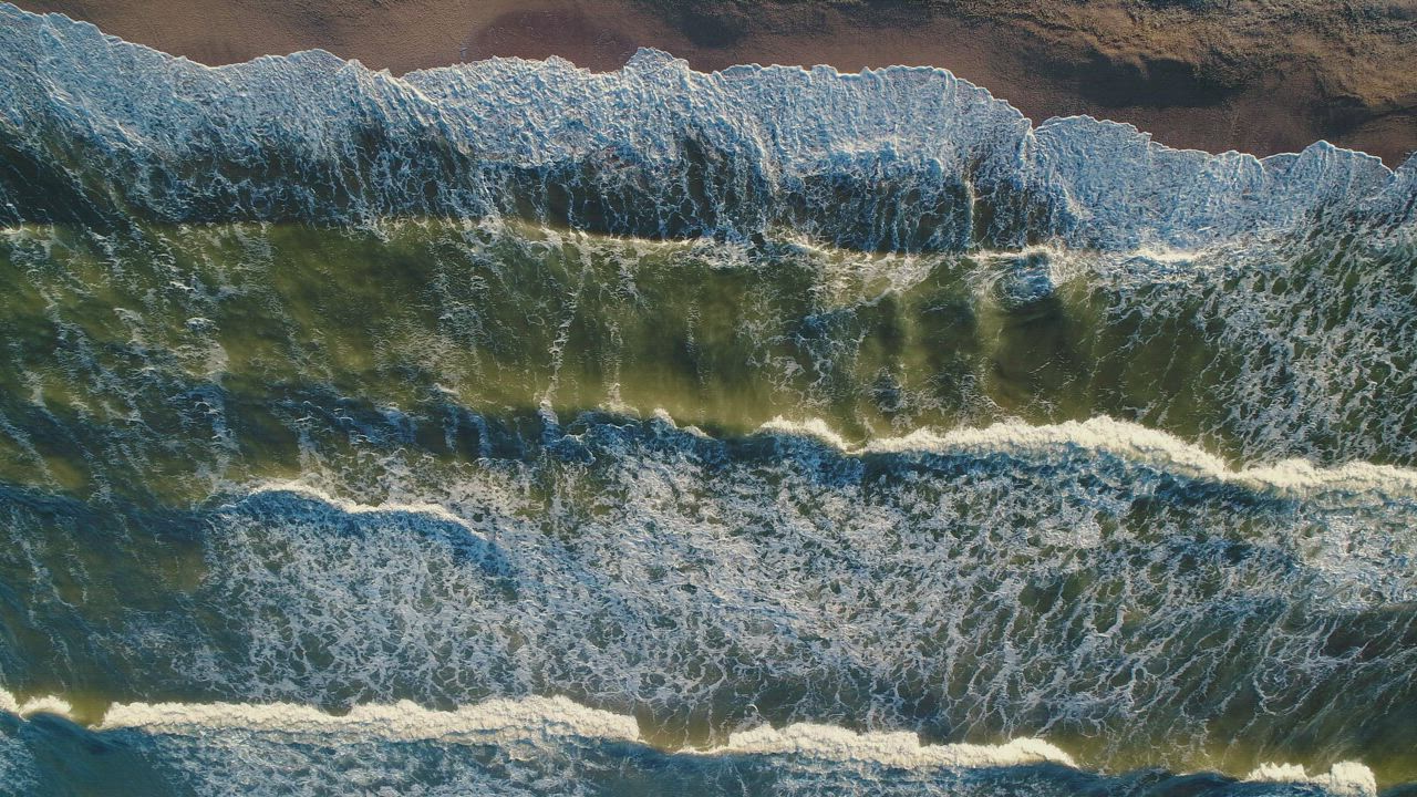 Foamy ocean waves colliding with a shoreline - Free Stock Video