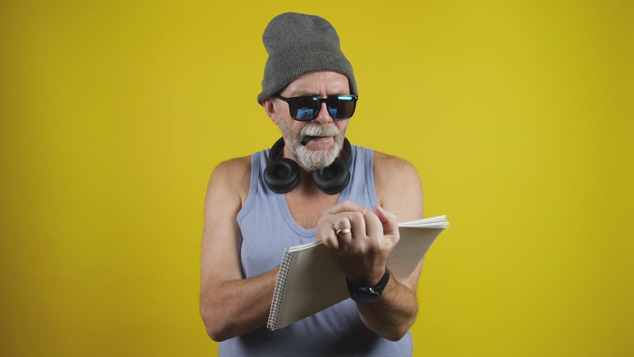 Old man writing be yourself on a notebook - Free Stock Video