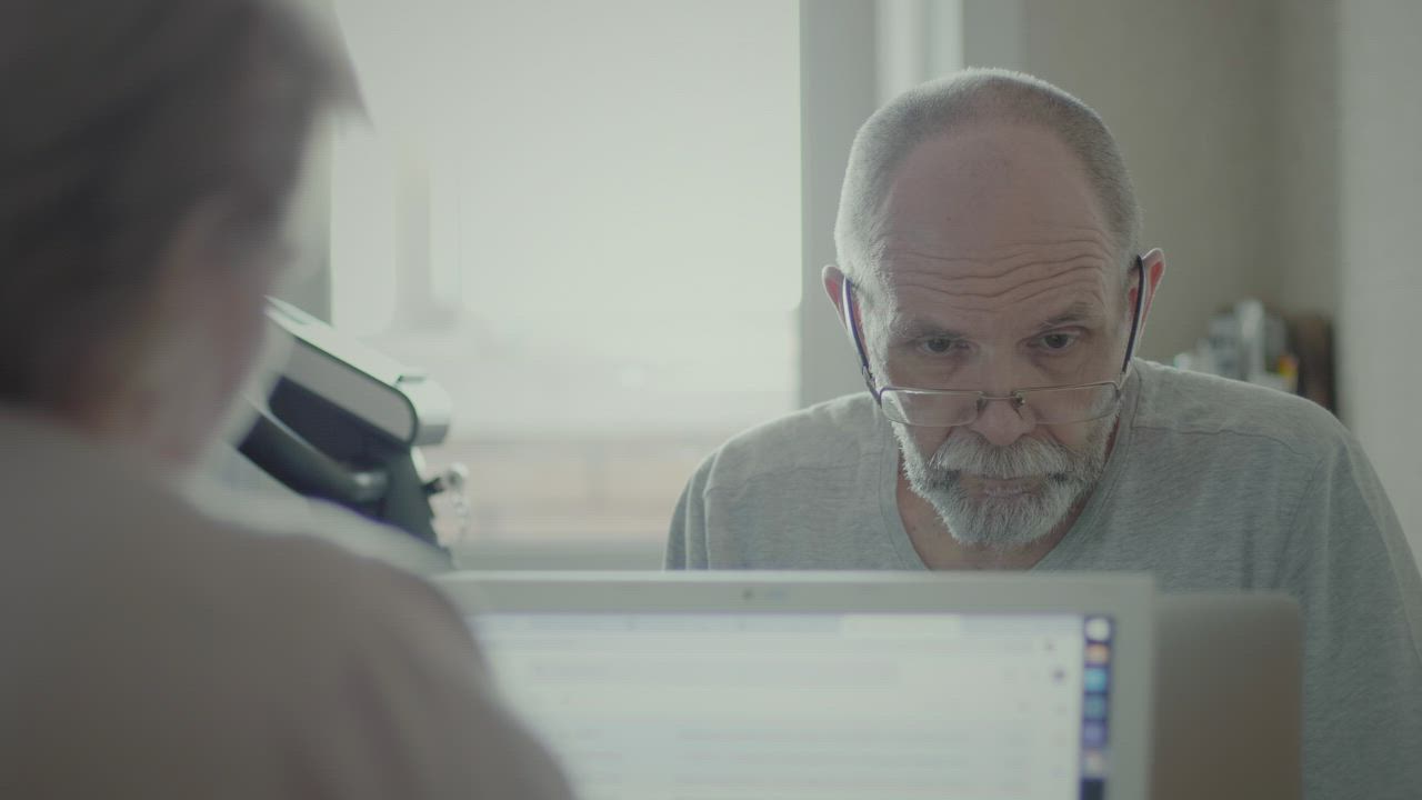 Senior man reading information on the computer - Free Stock Video