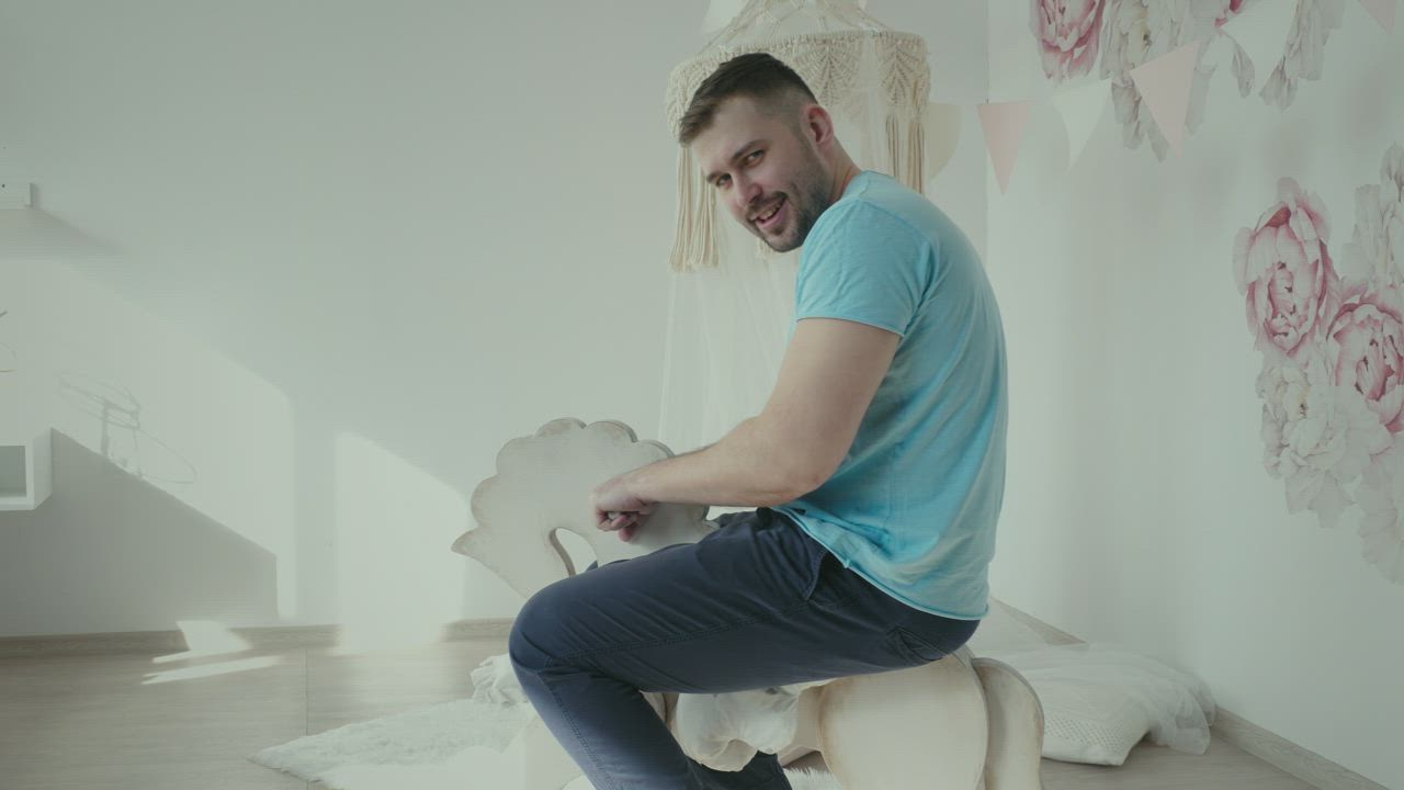 Young man riding a toy horse - Free Stock Video