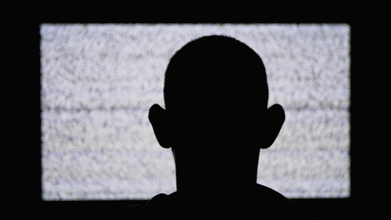Silhouette of a man in front of a TV with static - Free Stock Video