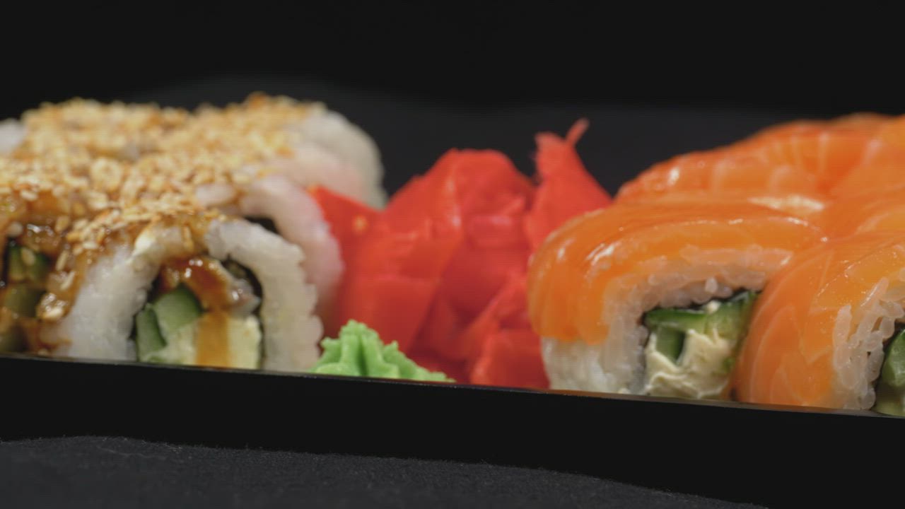 Salmon sushi rotating on a plastic tray - Free Stock Video