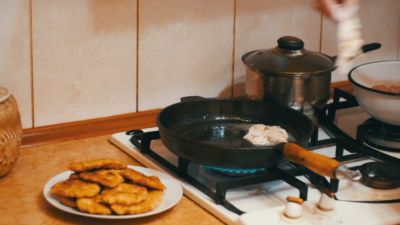 Housewife frying meat in a frying pan - Free Stock Video