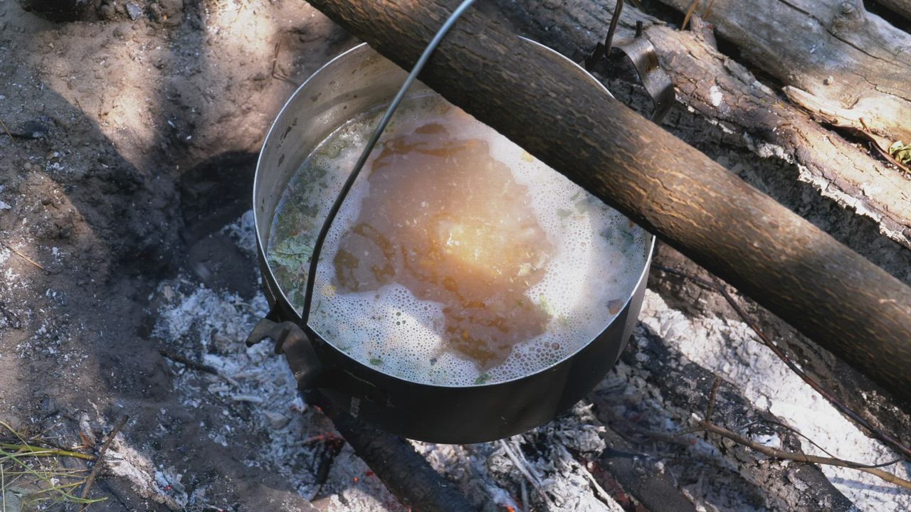 Casserole with boiling water on a campfire - Free Stock Video