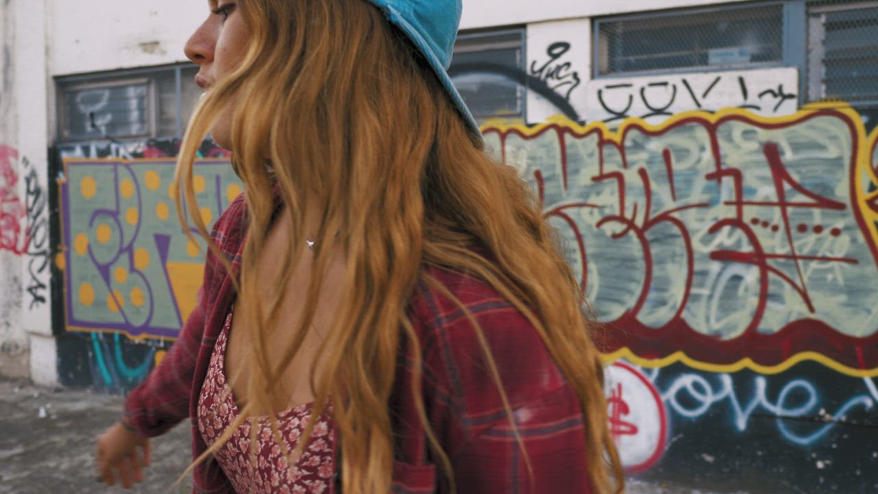 Woman moving in front of graffiti - Free Stock Video