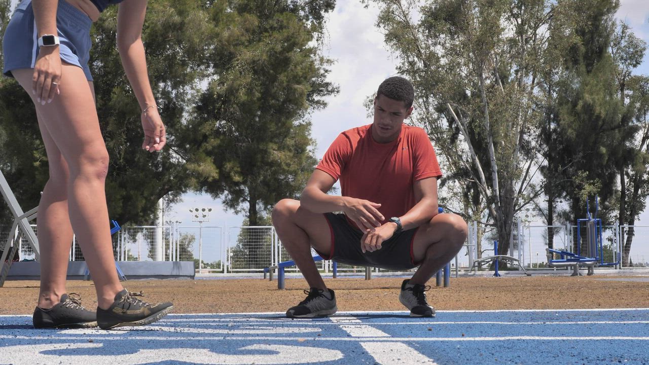 Young woman getting into position for sprinting - Free Stock Video