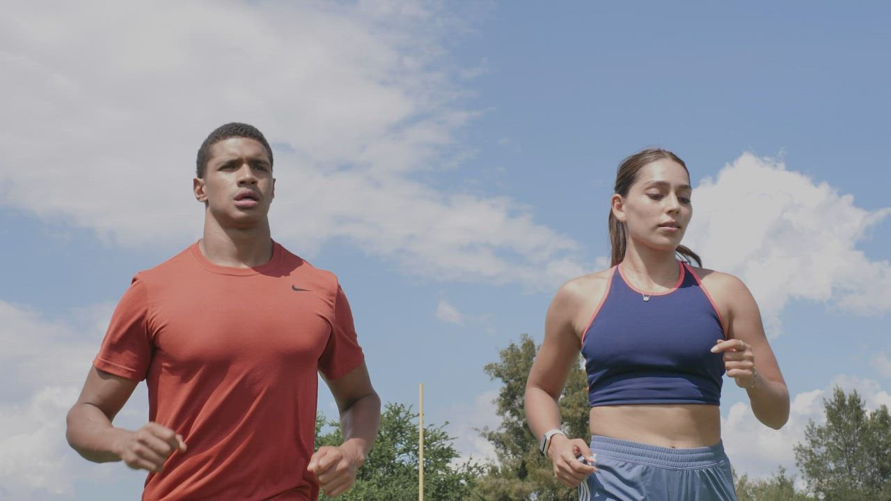 Two people running outdoors on a sunny day - Free Stock Video