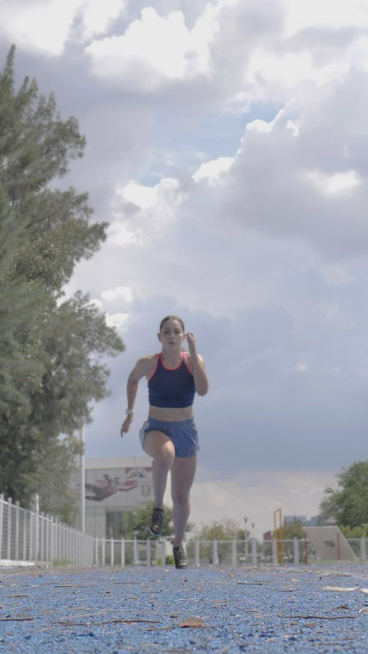 Woman running above the camera on a running track - Free Stock Video