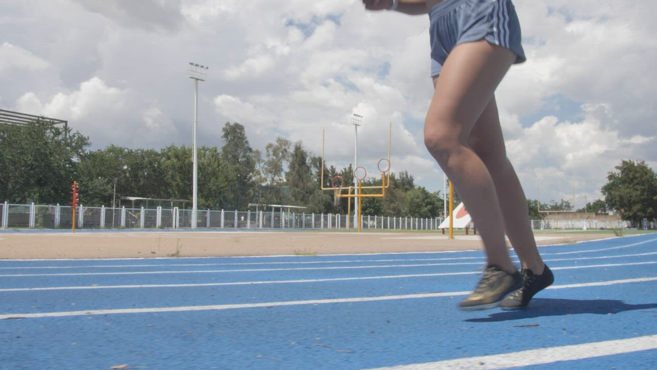 Legs of a woman when running on a running track - Free Stock Video