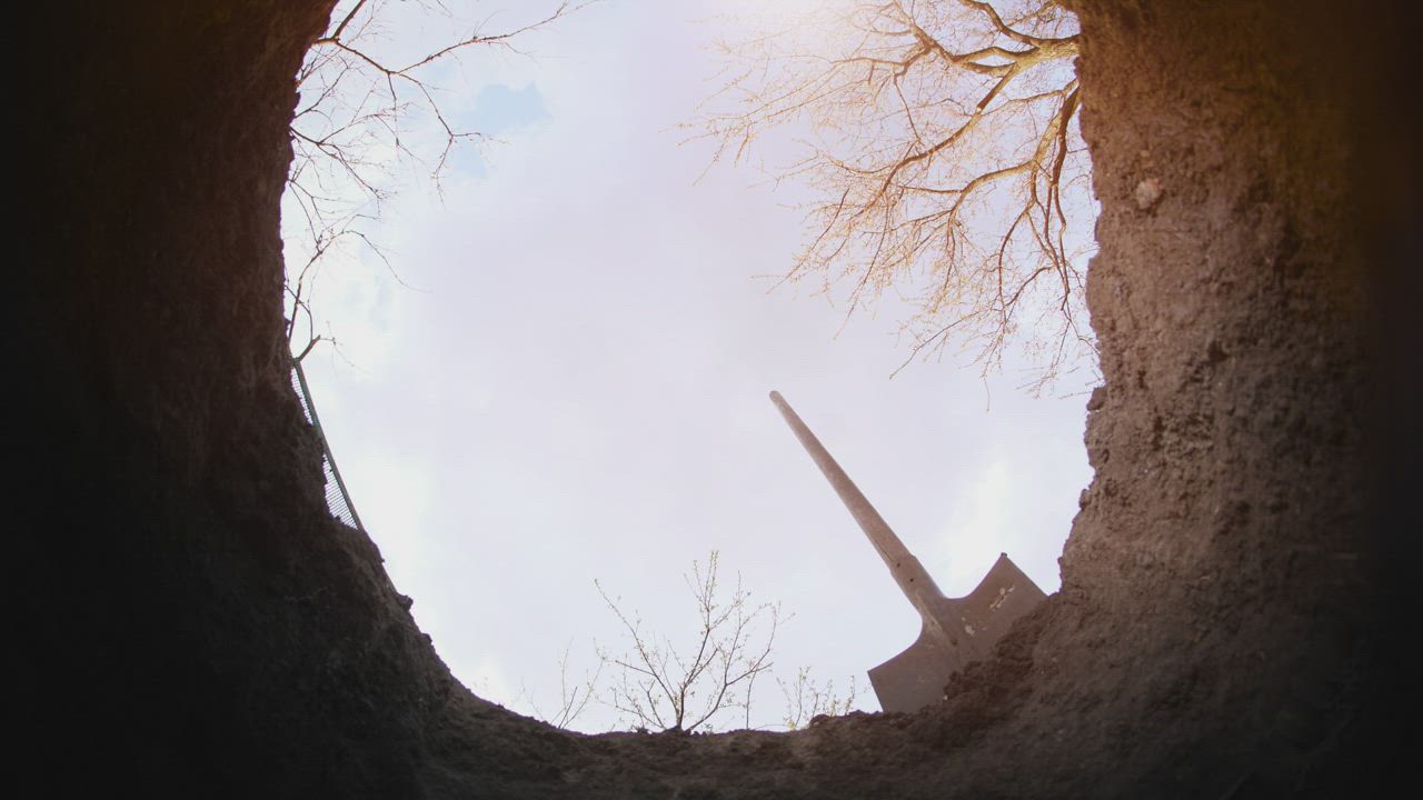 Man throws dirt into a grave - Free Stock Video