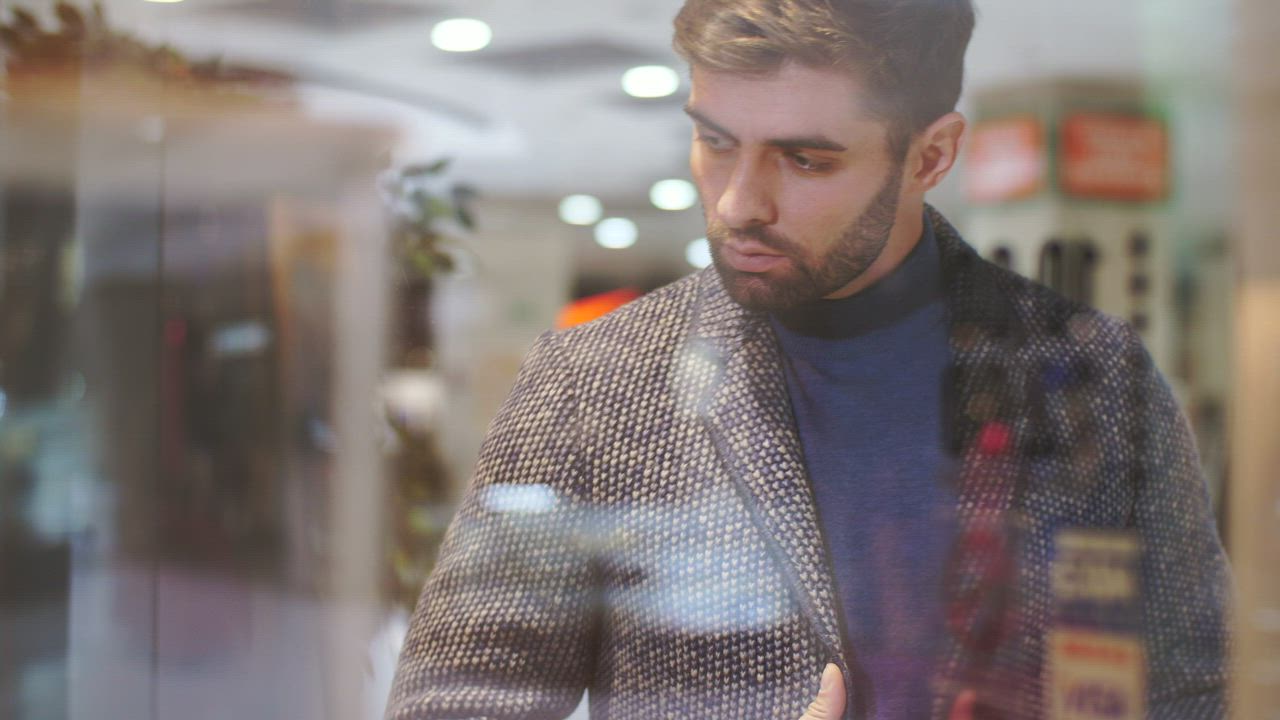 Man looking at the sideboard of a clothing store - Free Stock Video