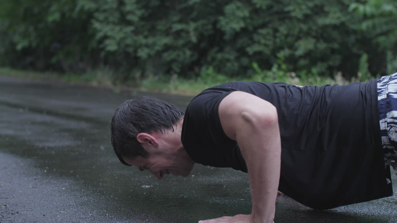 Man doing hard push ups in the rain - Free Stock Video