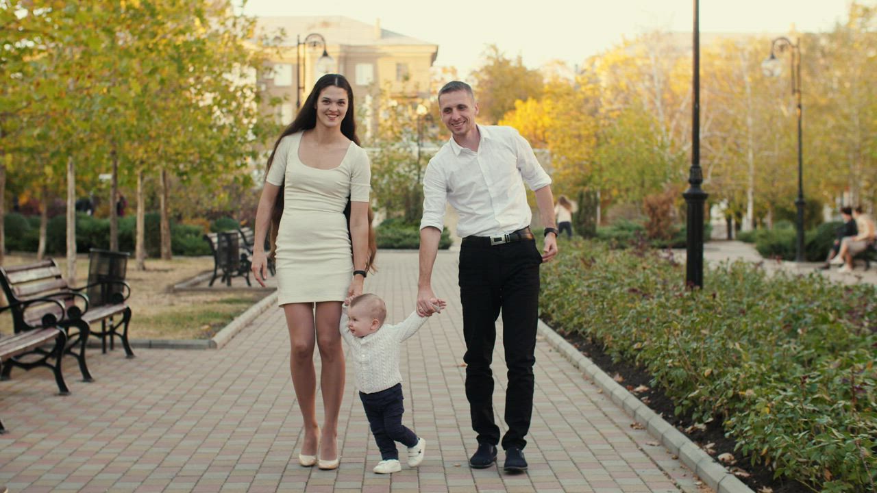 Parents walking with their little son in the park - Free Stock Video