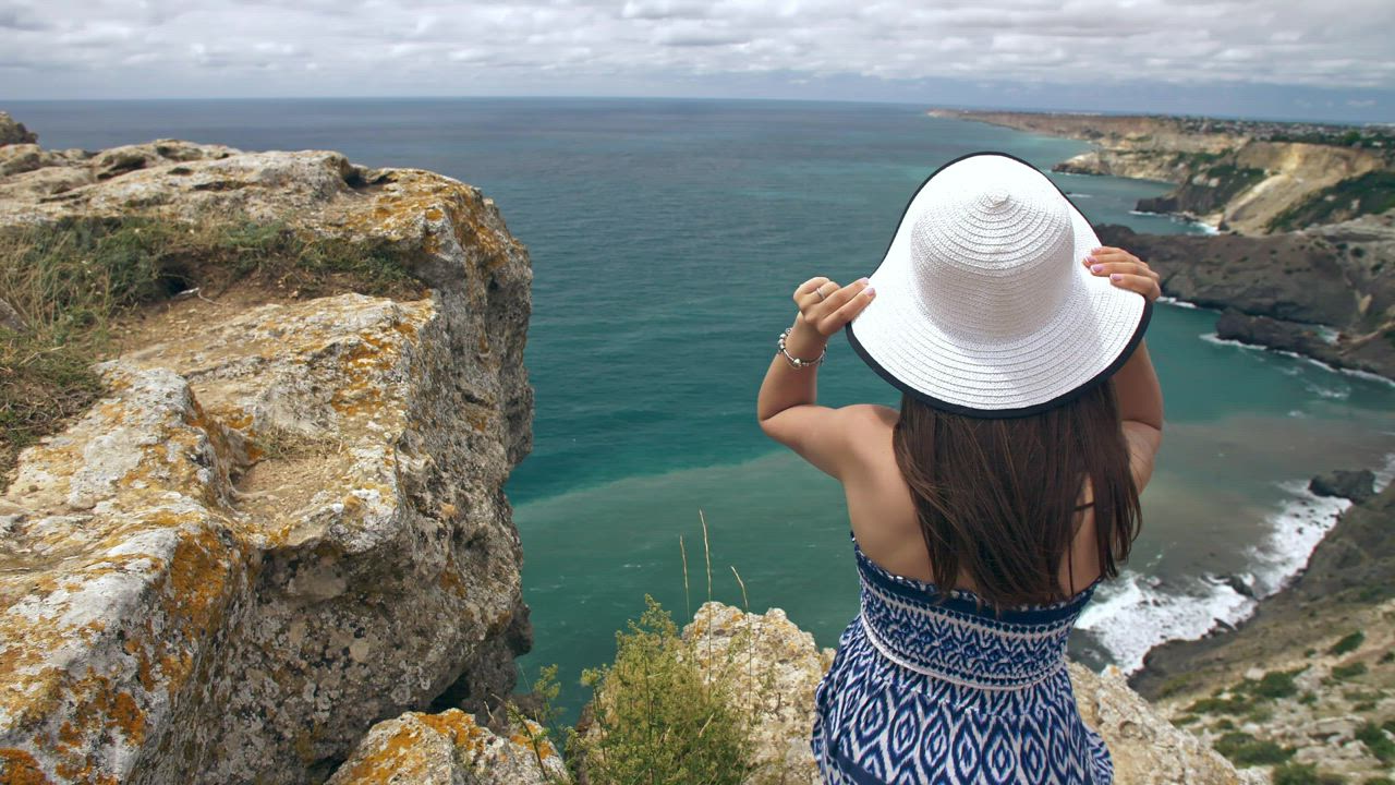Tourist looking at the beach scenery from above - Free Stock Video
