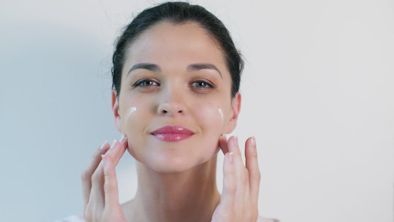 Young woman applying skin care cream on face - Free Stock Video