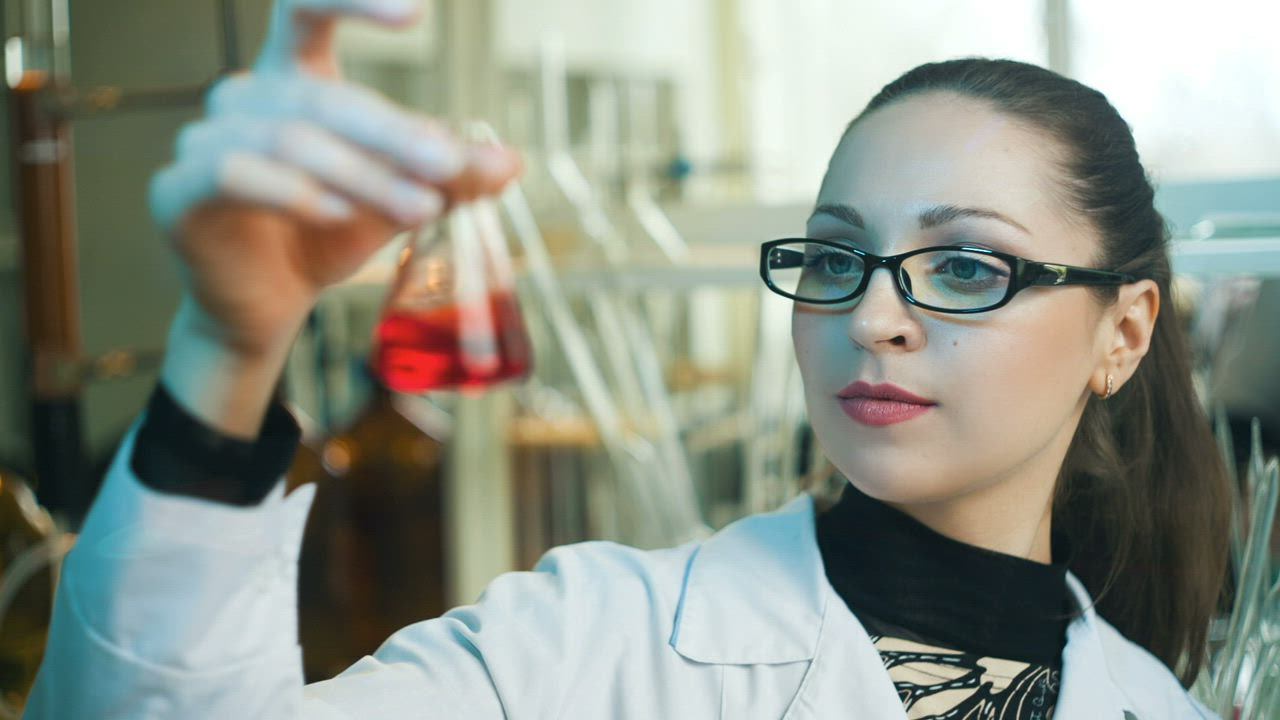 Chemistry shaking a conical flask with red liquid - Free Stock Video
