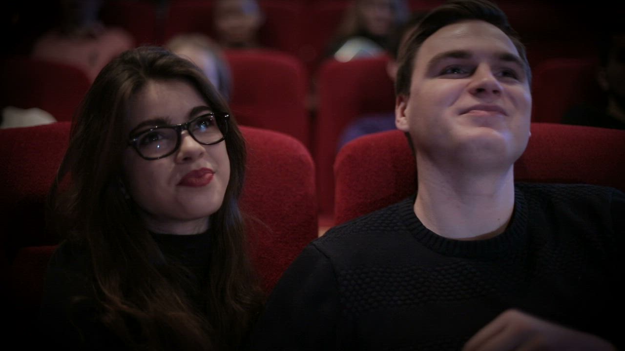 Couple in love watching a movie at the cinema - Free Stock Video