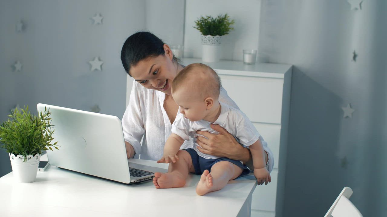 Mother working on her laptop with her son - Free Stock Video