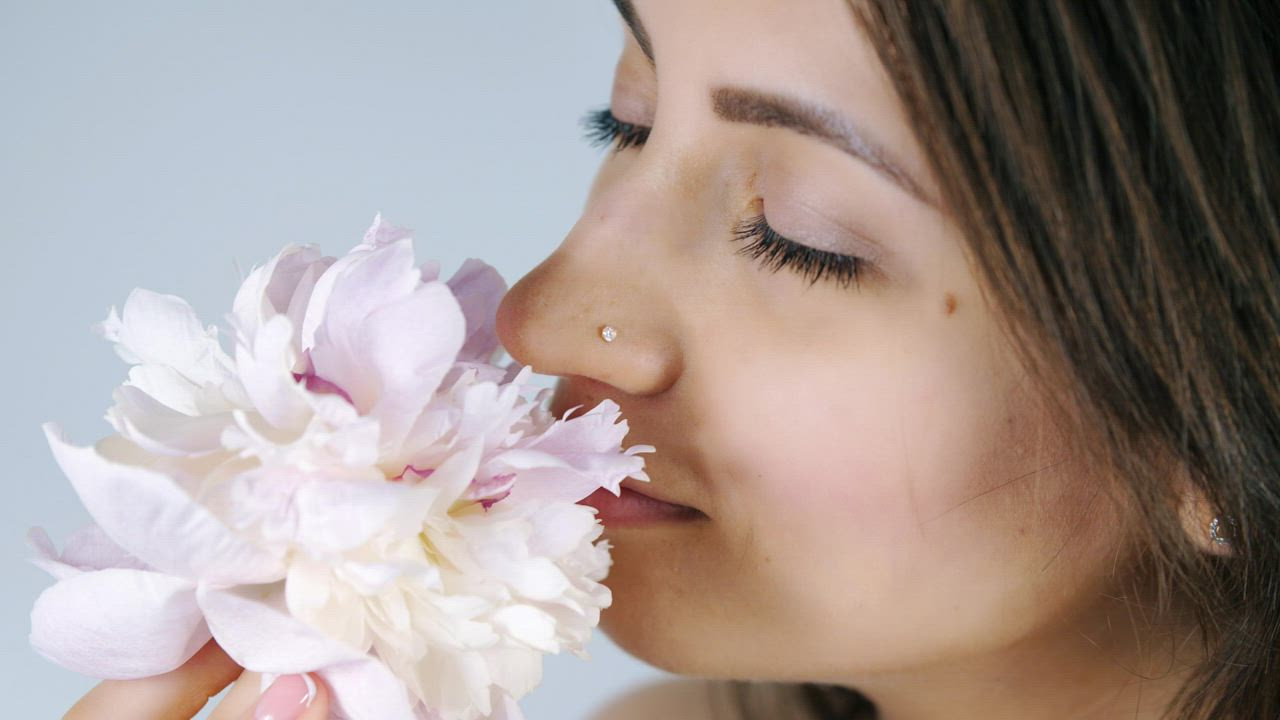 Young woman smelling a white flower - Free Stock Video