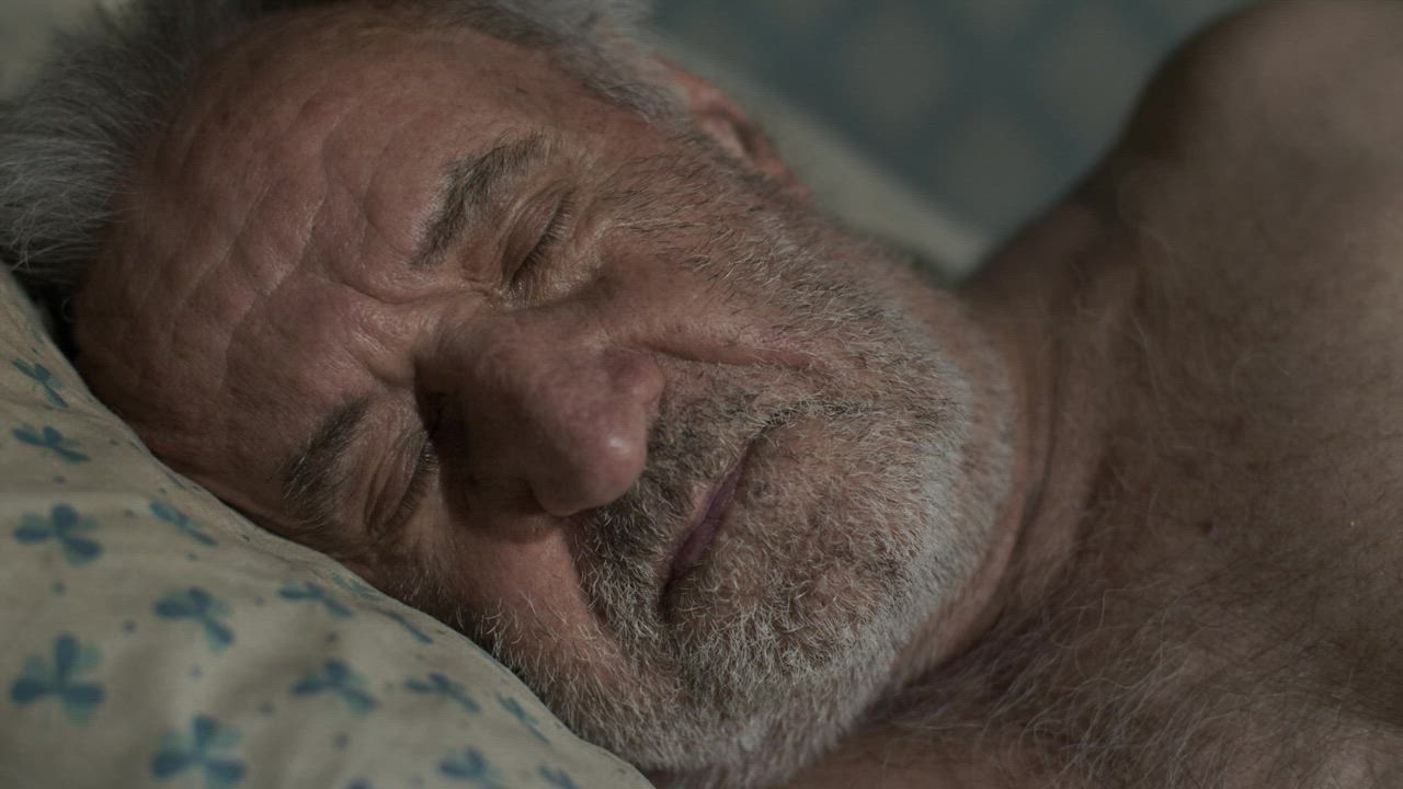 Tired old man wakes up in his bed - Free Stock Video