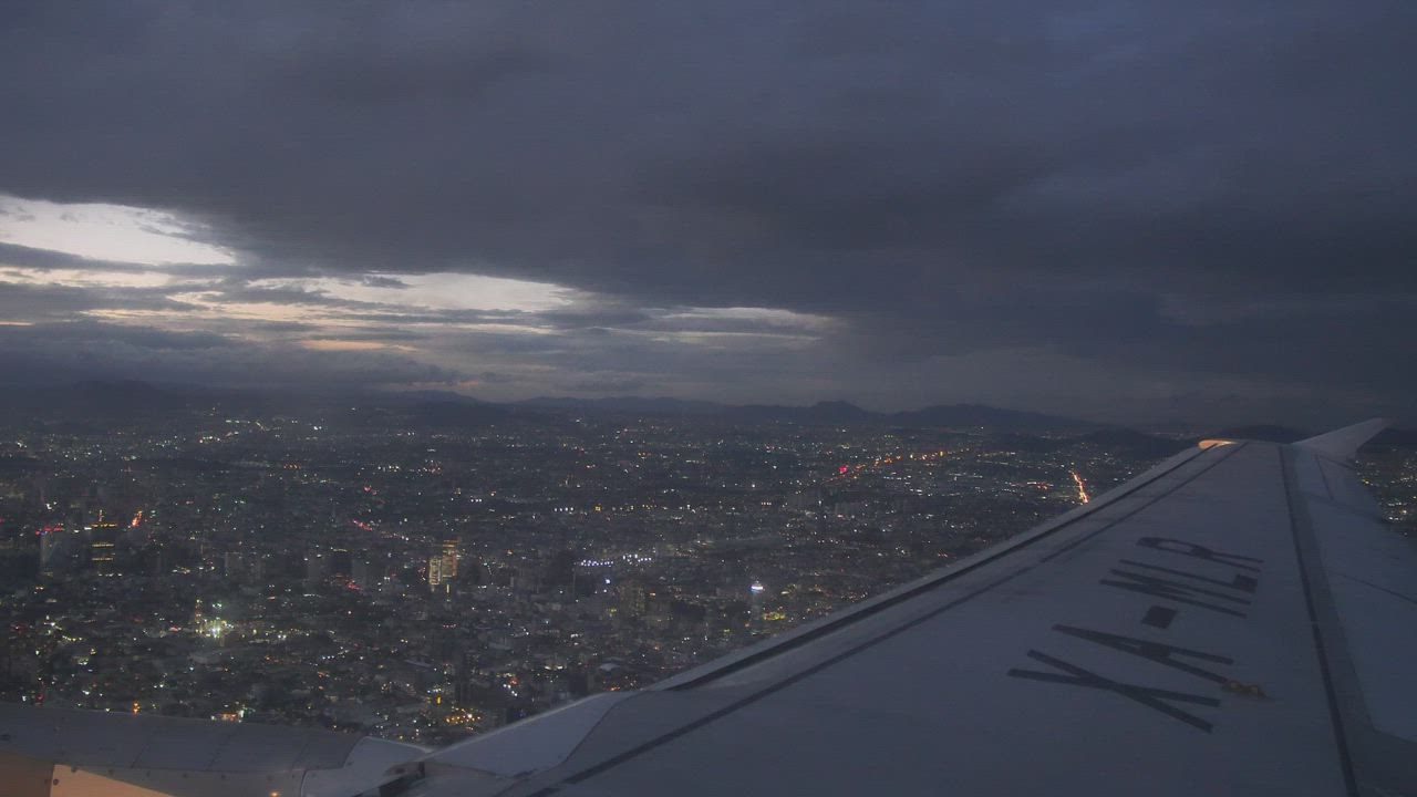 Plane flying over a city at night - Free Stock Video