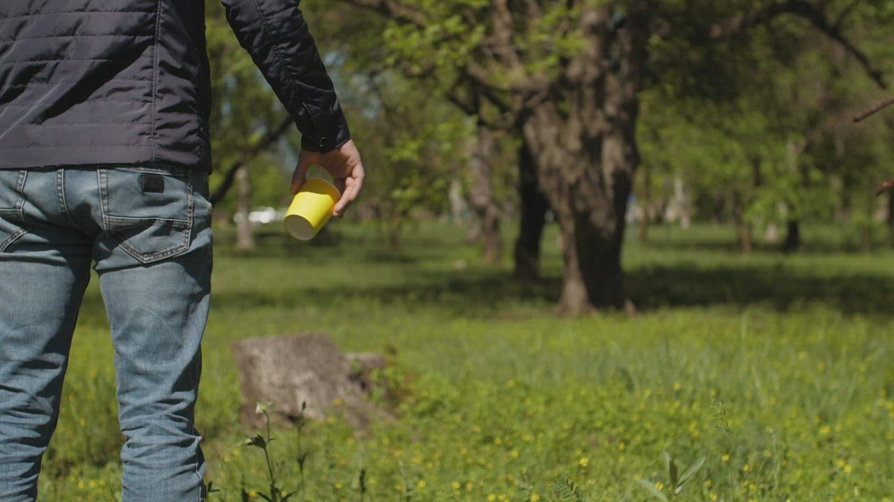Person throwing garbage in nature - Free Stock Video