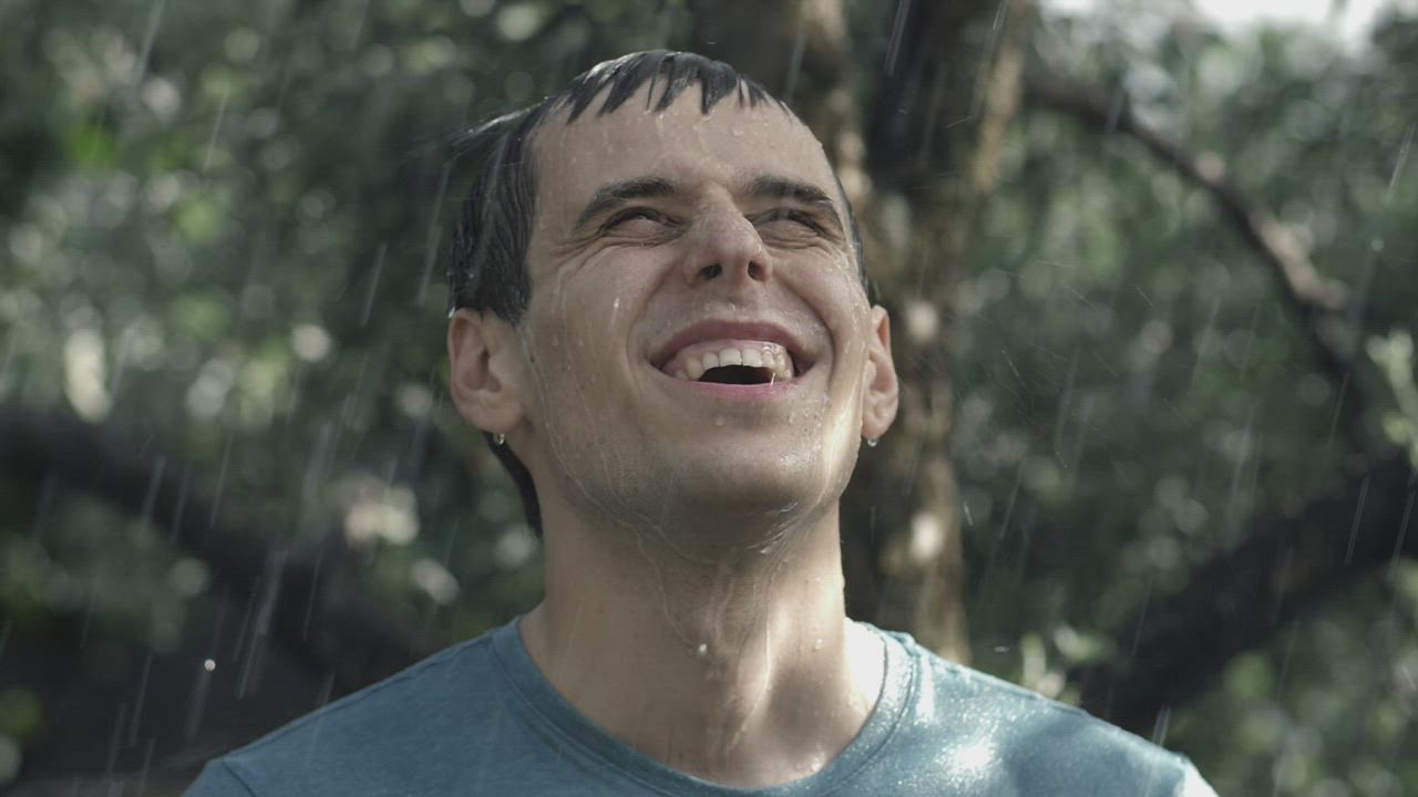 Man happily getting wet in the rain - Free Stock Video