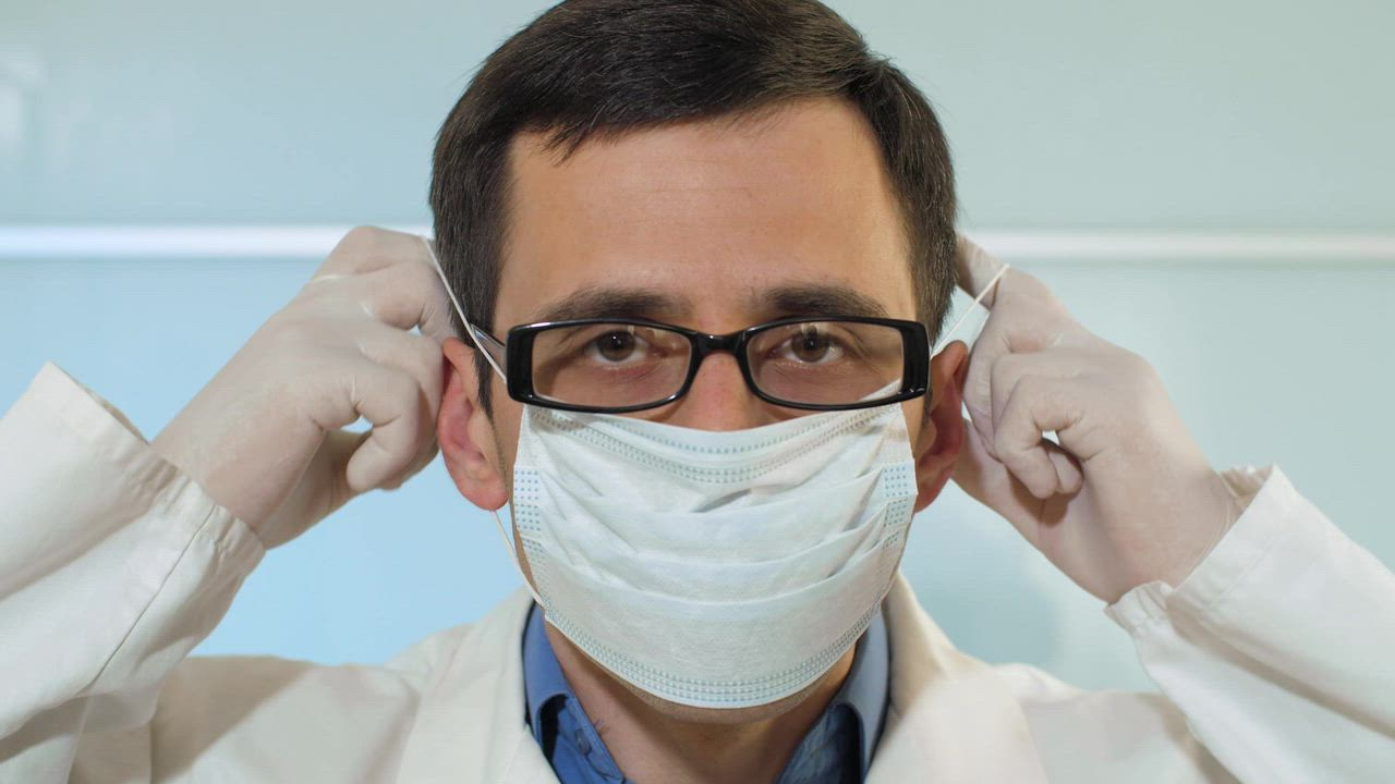 Doctor puts on a mask in the hospital, portrait - Free Stock Video