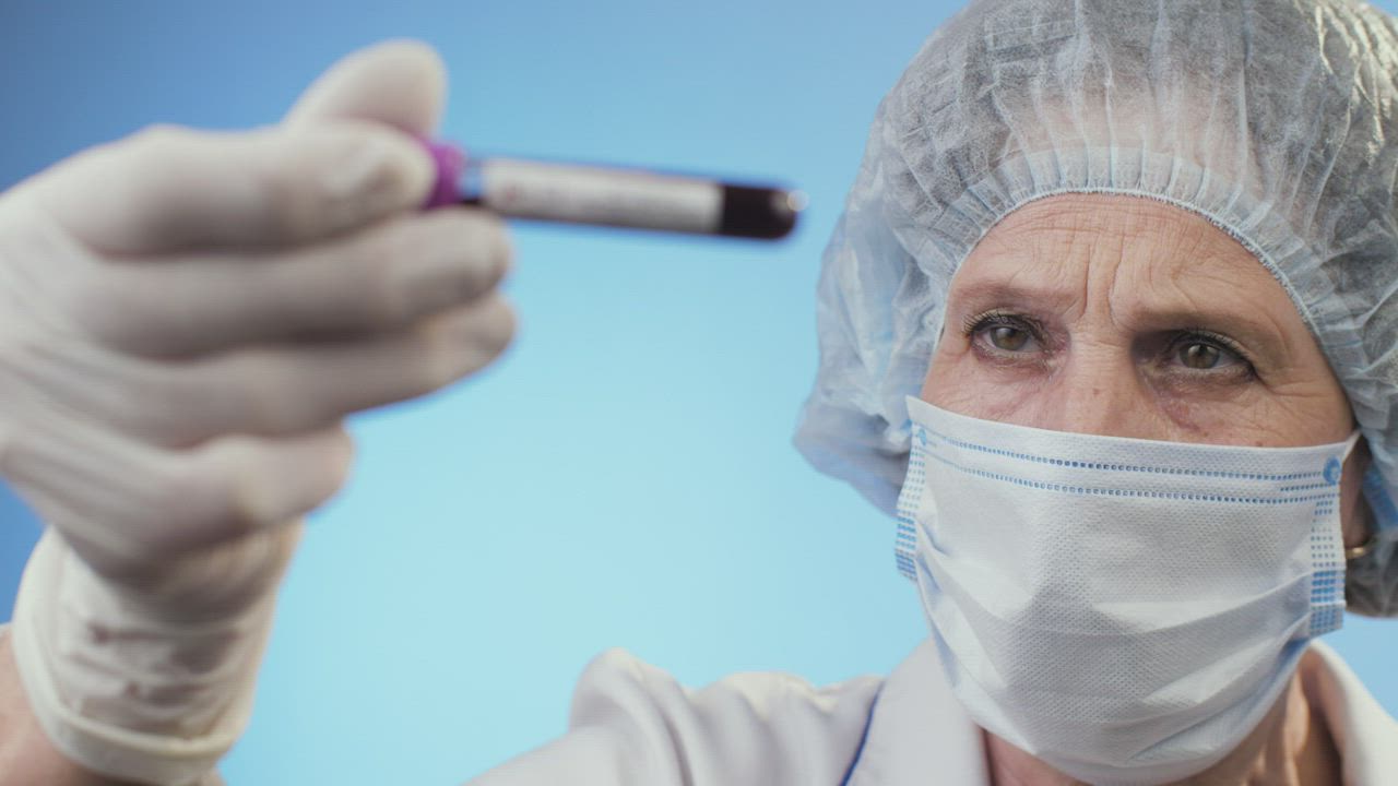 Old doctor checking positive test for covid-19 - Free Stock Video