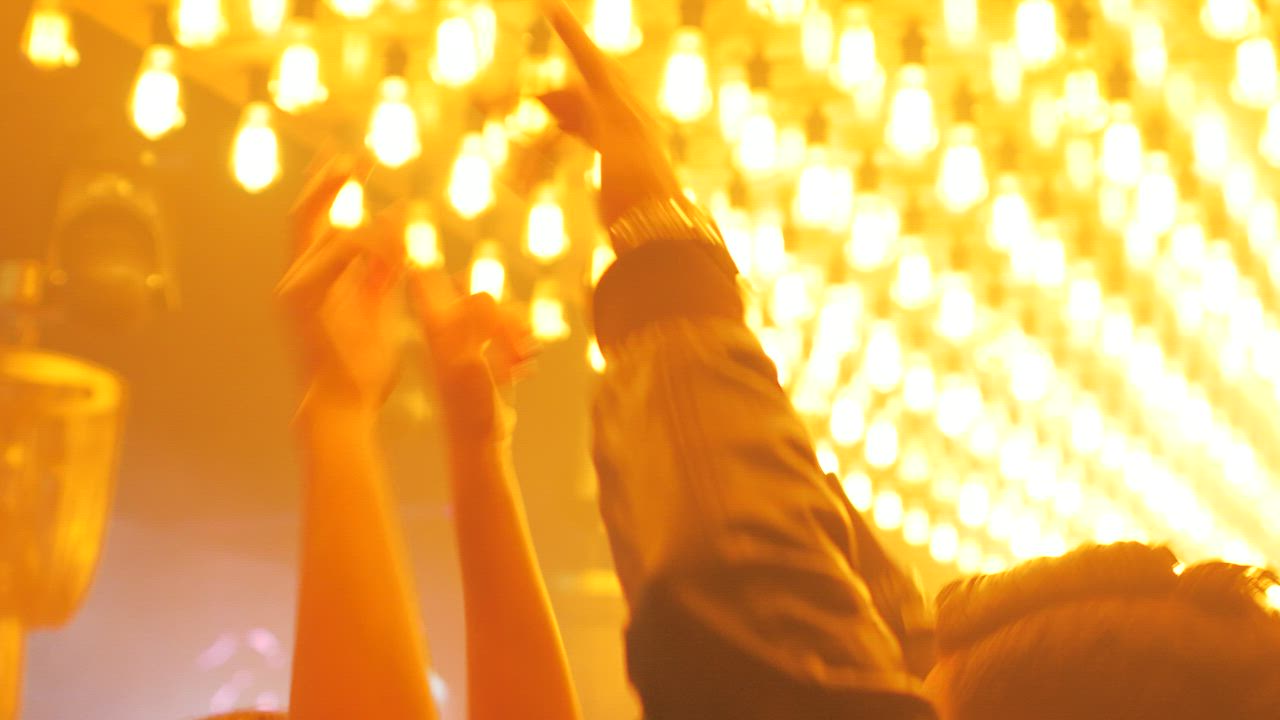 Hands raised high on a nightclub dance floor - Free Stock Video