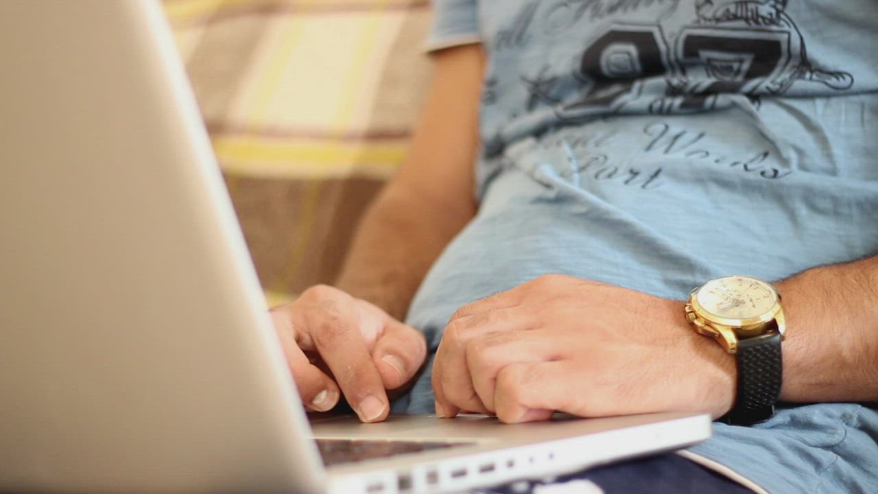 Man working with a computer in her lap - Free Stock Video