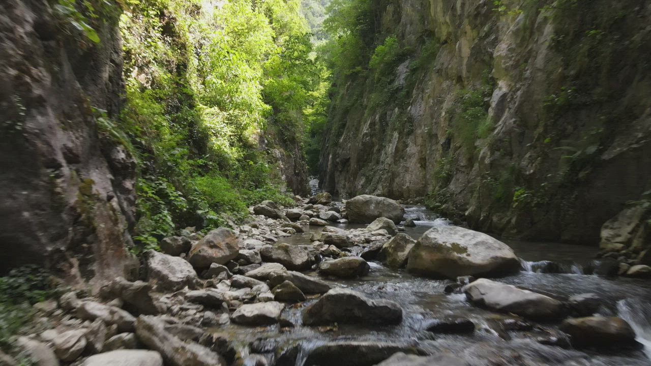 Crossing a river between two mountains - Free Stock Video