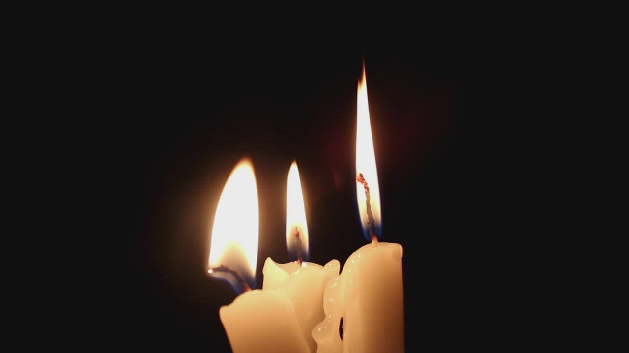 Three candles lit in the dark together - Free Stock Video