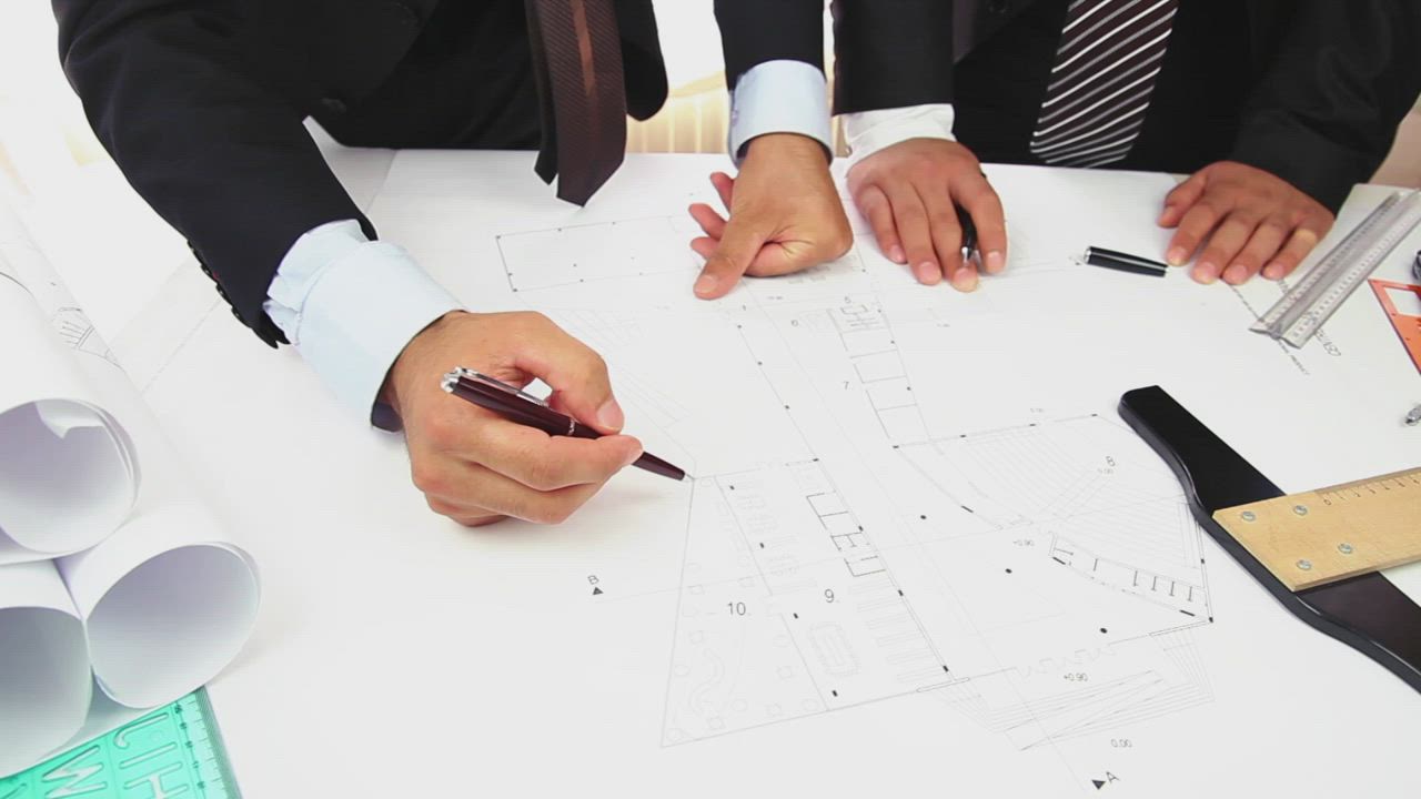 Two people discussing an architectural blueprint - Free Stock Video