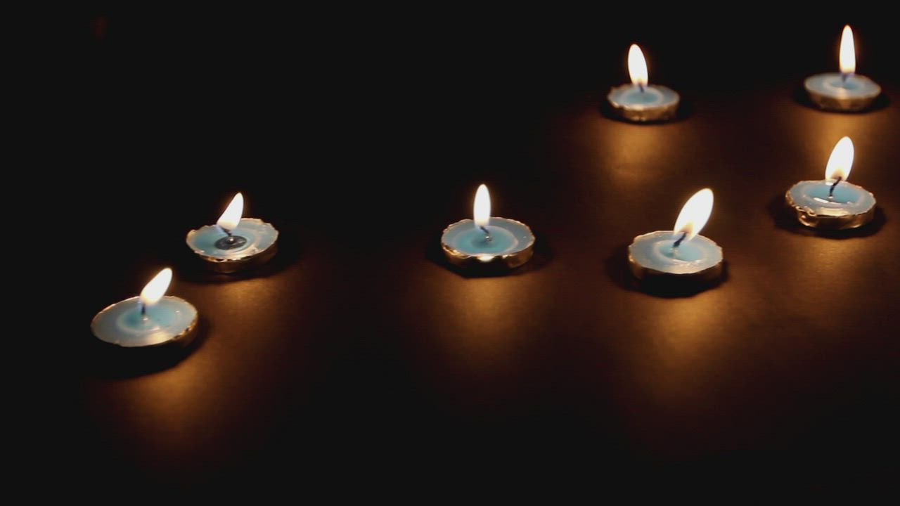 Small lit candles in the dark - Free Stock Video