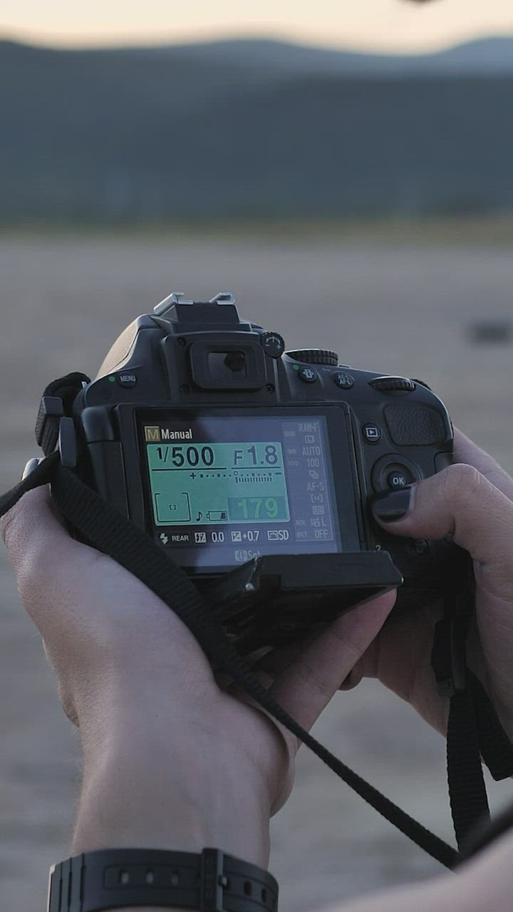 Young photographer setting up his camera outdoors - Free Stock Video