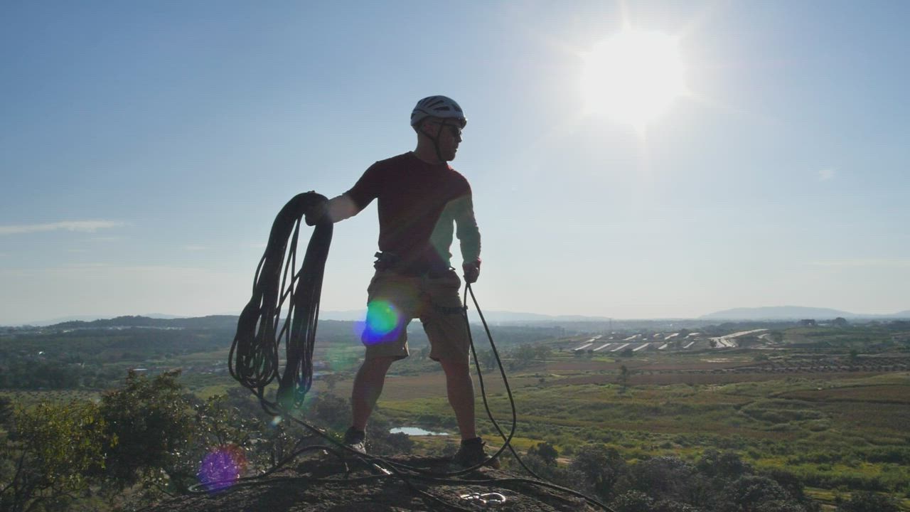 Man throwing a rope from the top of a hill - Free Stock Video