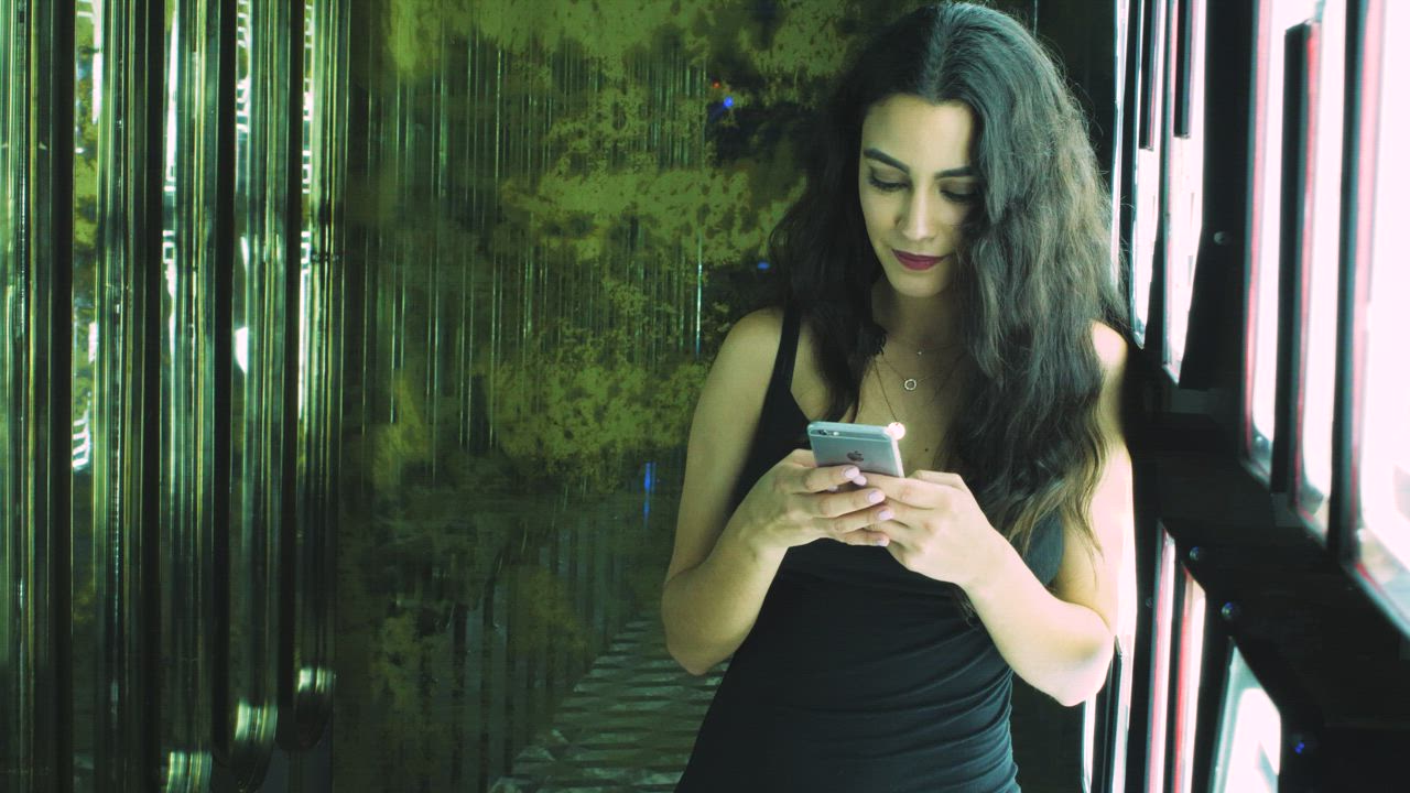 Woman texting in a club entrance - Free Stock Video