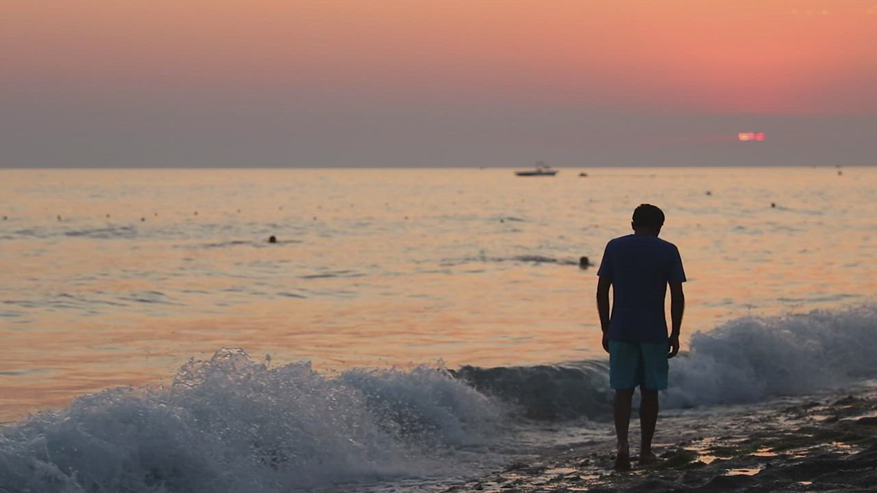 Depressed man in the seashore at sunset - Free Stock Video