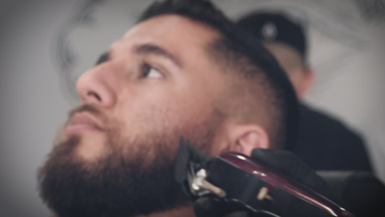 Barber and his electric hair trimmer - Free Stock Video