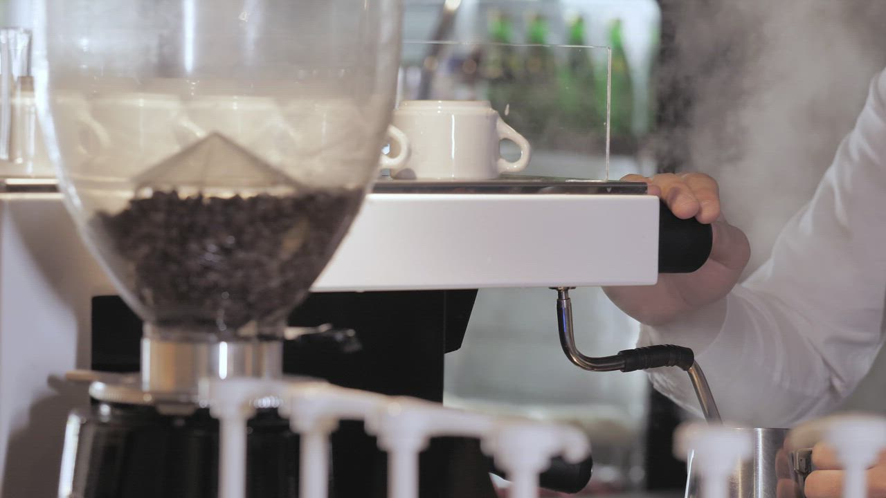 Serving an espresso in a cup of a coffee pot - Free Stock Video