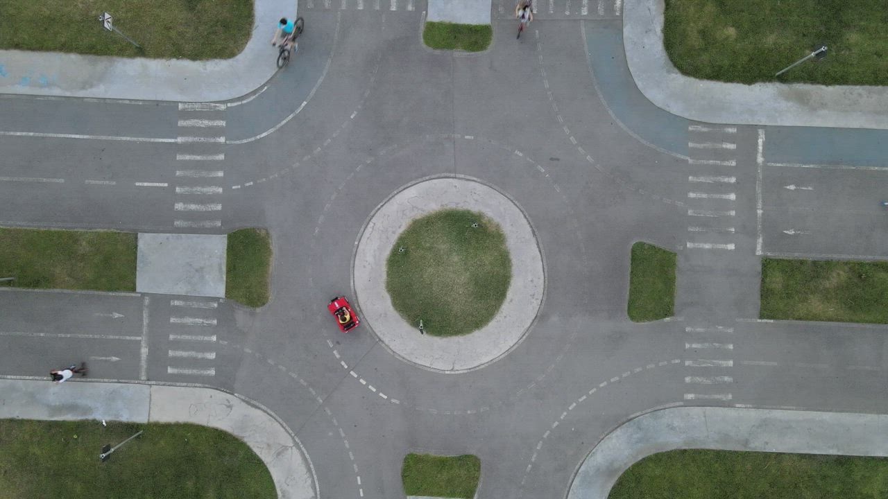 Roundabout in a road with people on bikes - Free Stock Video