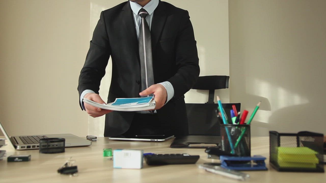 Man in a suit organizing his office - Free Stock Video