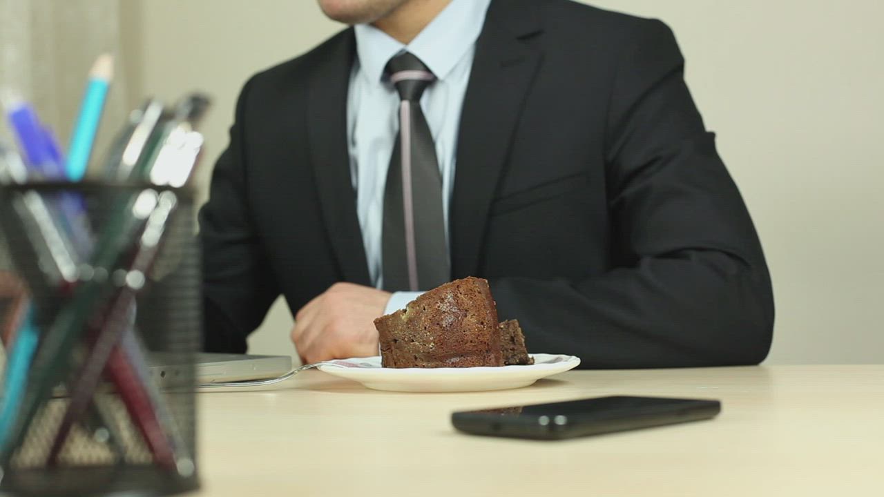 Businessman eating while working at the computer - Free Stock Video