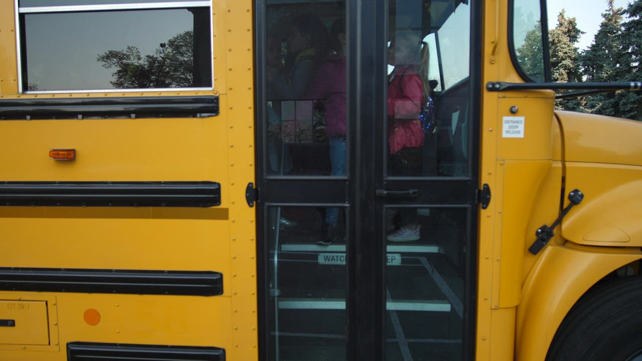Children getting off a yellow school bus - Free Stock Video