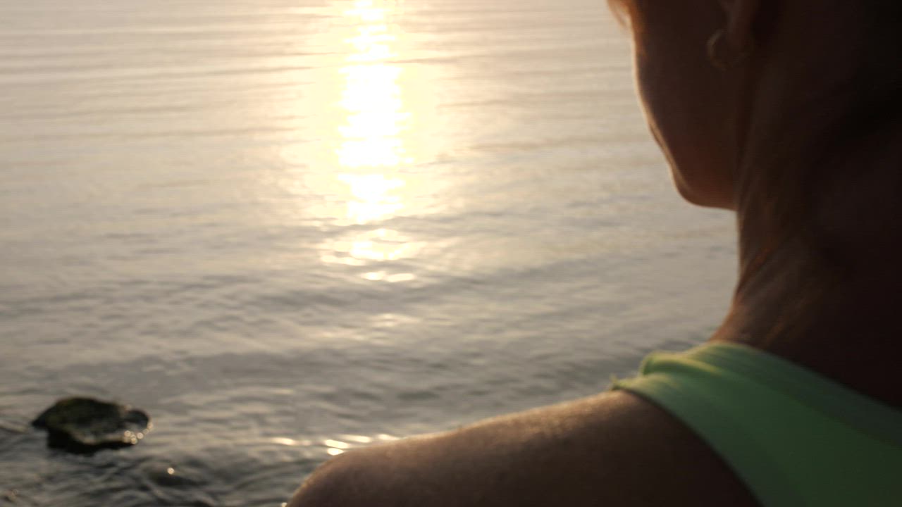 Woman checks her smart watch while watching sunset - Free Stock Video
